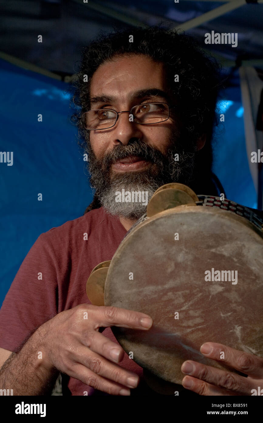 Musician plays tambourine in his music stall at Glebe Markets in Sydney ...