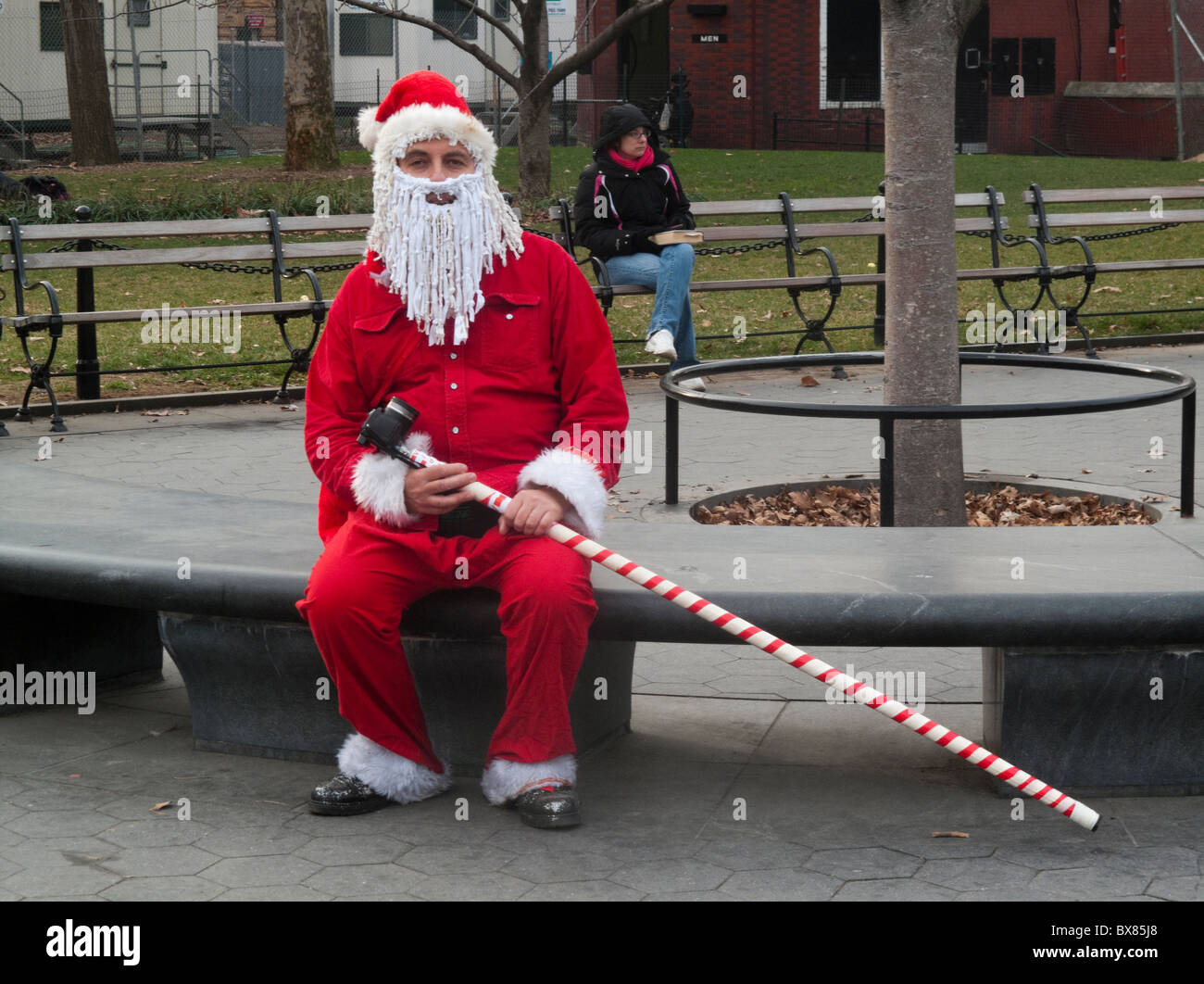 New York, NY SantaCon - Man sitting on a bench in Washington Square ...