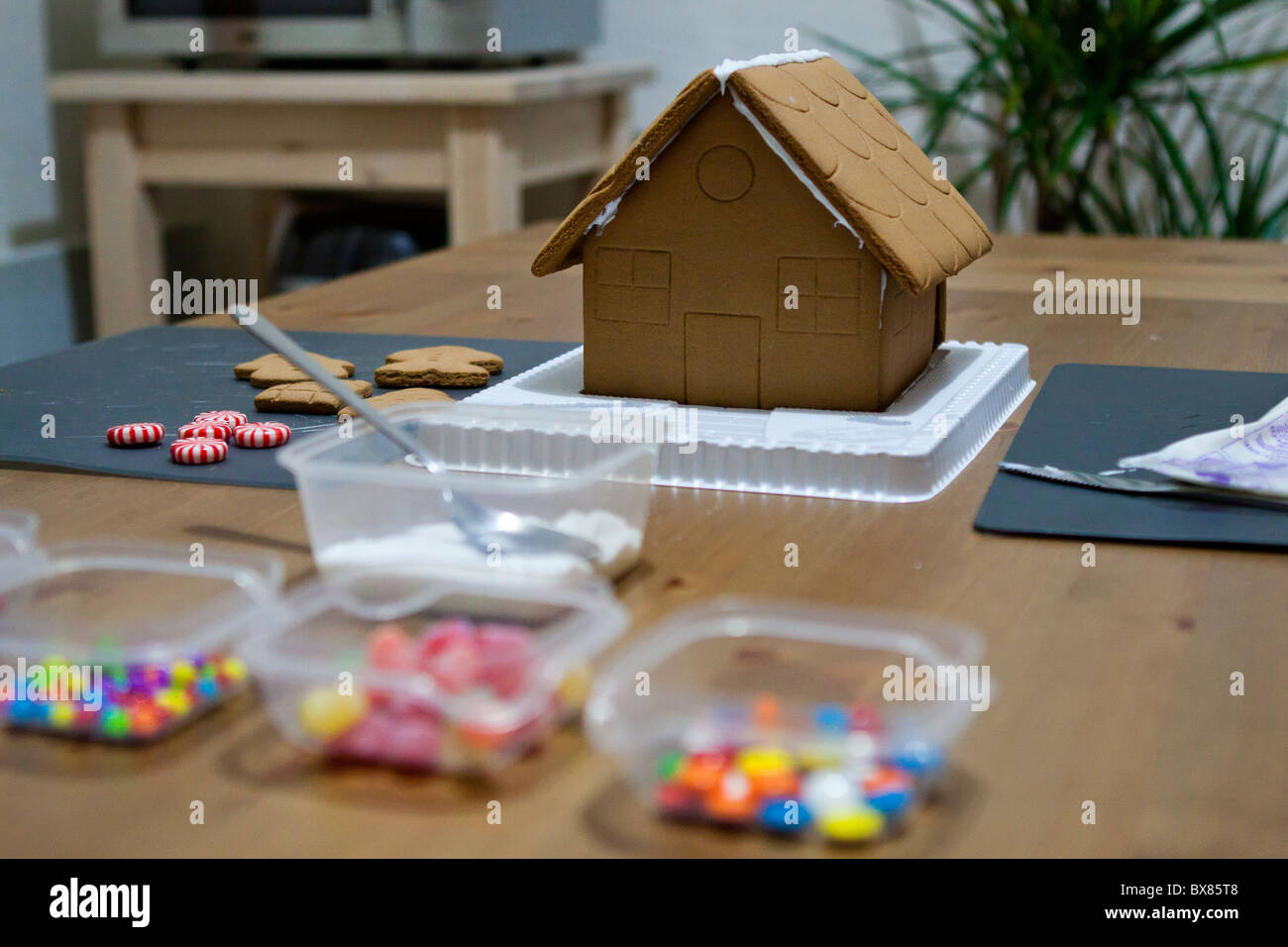 Gingerbread house being built, with candies in the foreground Stock ...