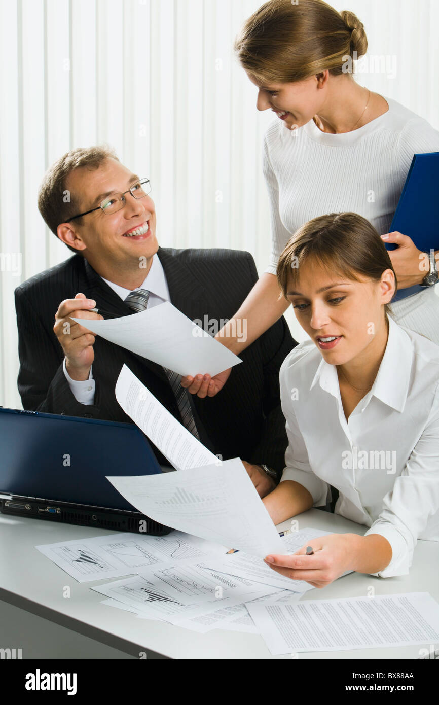 Charming secretary is showing important document to her boss in the ...
