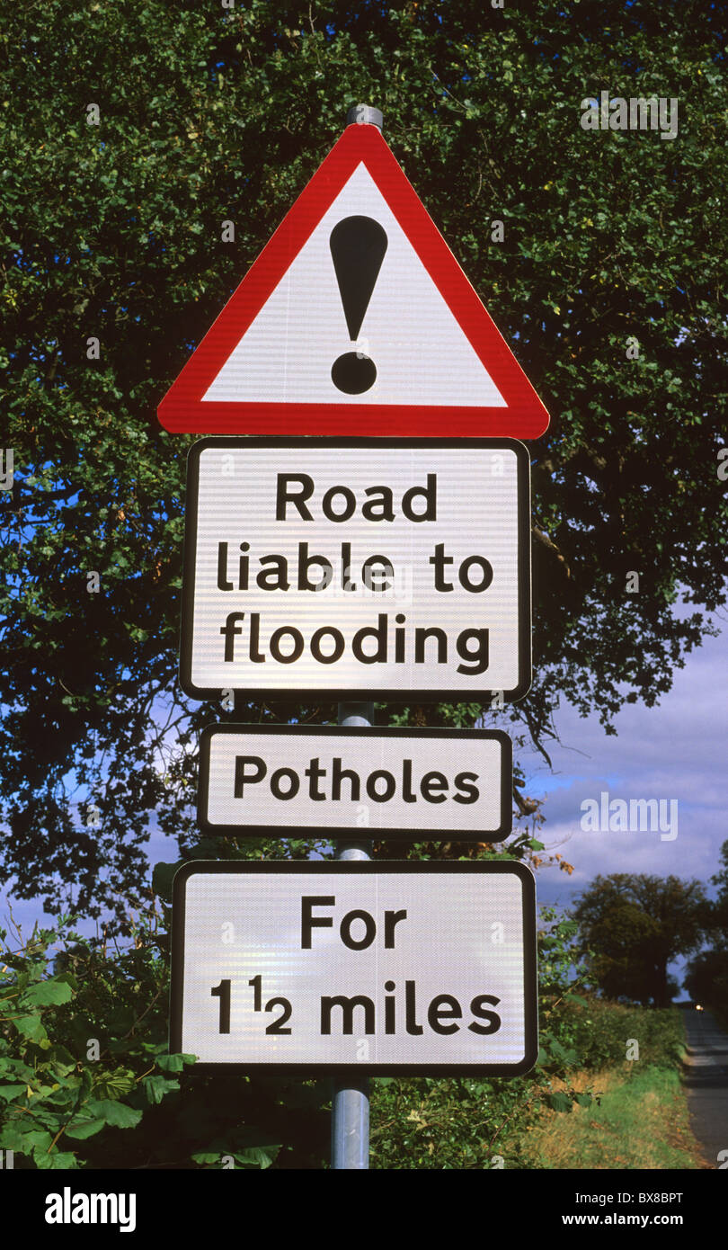 warning roadsign of road liable to flooding and potholes UK Stock Photo ...