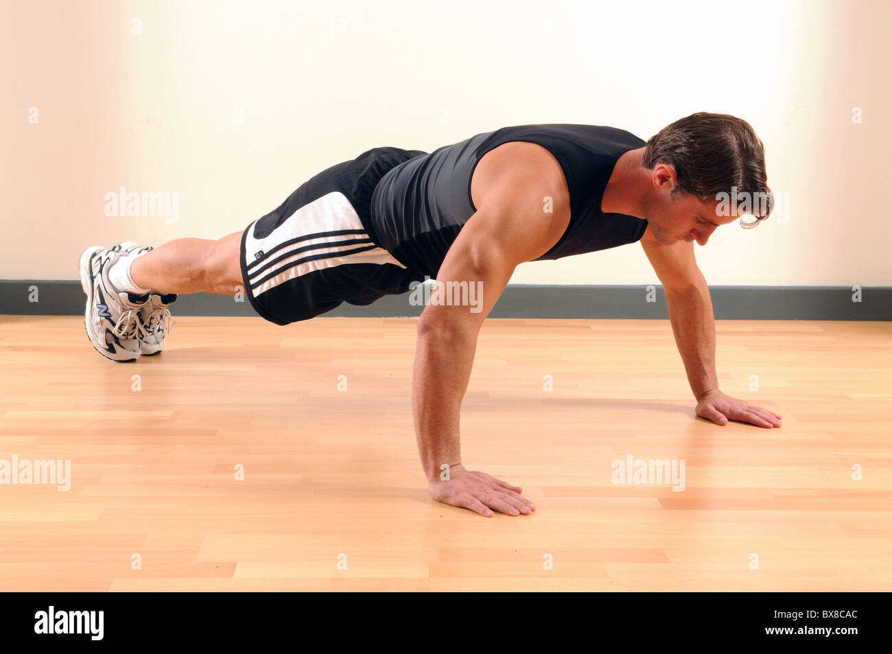 25-30 yr old male exercising in health club studio Stock Photo - Alamy