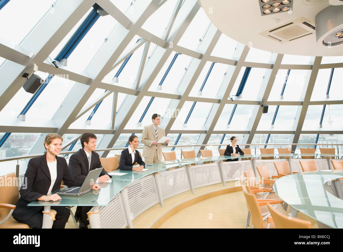 Businesspeople sitting at the round table listening to their colleague ...
