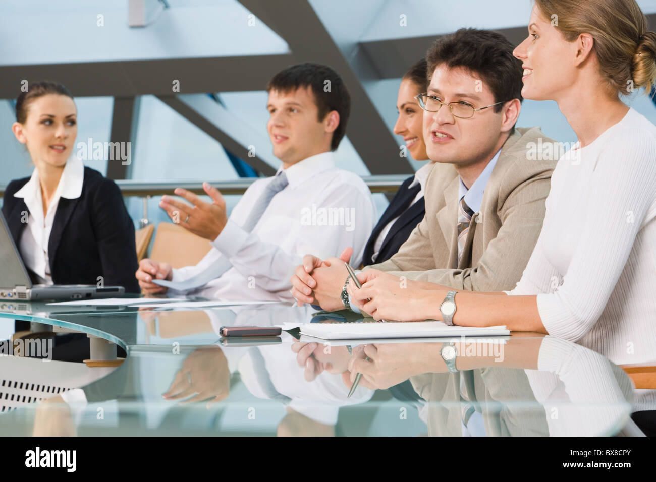Business team are sitting at the glassy table and discussing important ...