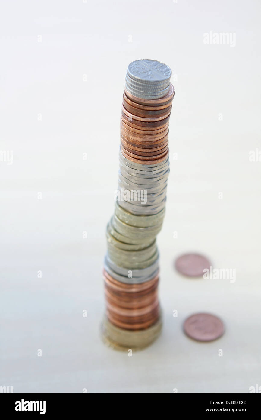 a tall stack of different denomination sterling coins with two loose ...
