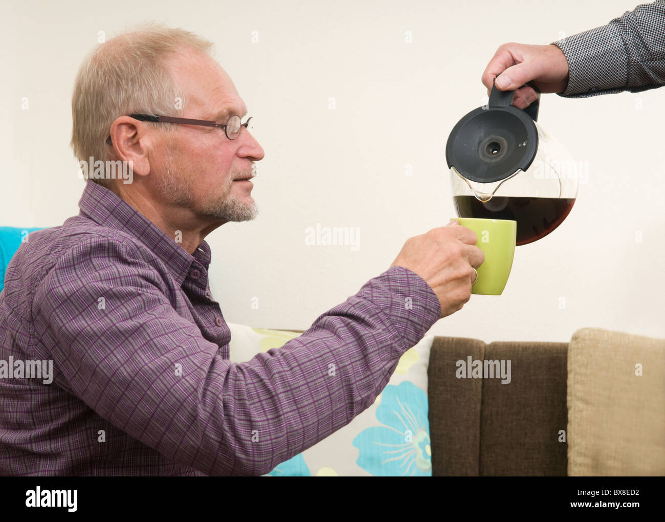 Senior man getting a refill of his cup of coffee Stock Photo - Alamy