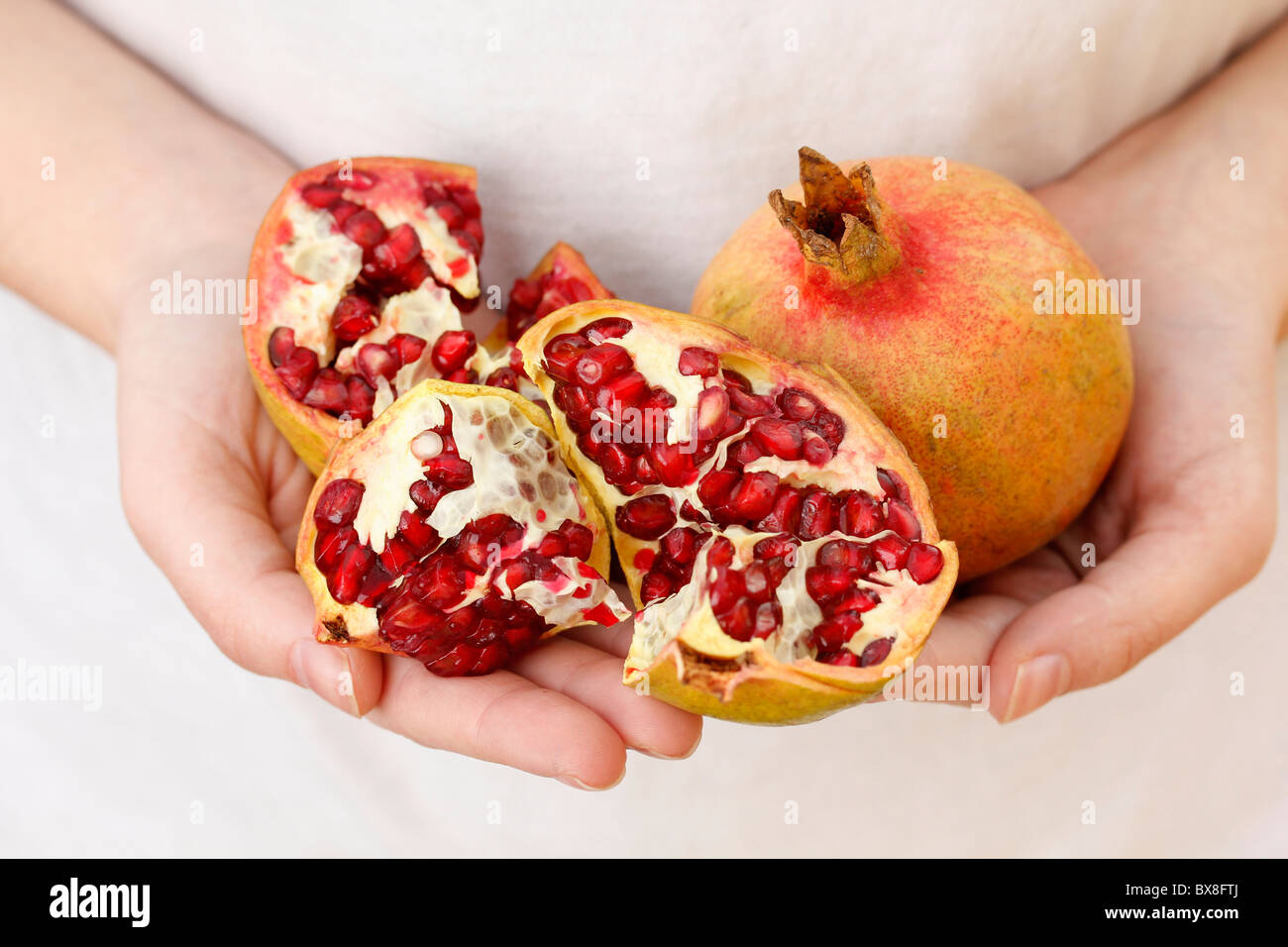 Hand holding pomegranate hi-res stock photography and images - Alamy