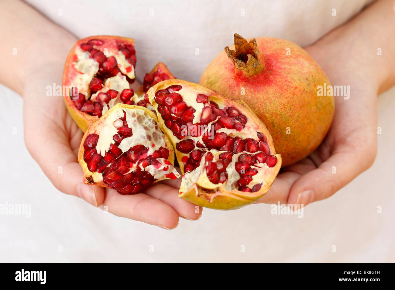 Hand holding pomegranate hi-res stock photography and images - Alamy