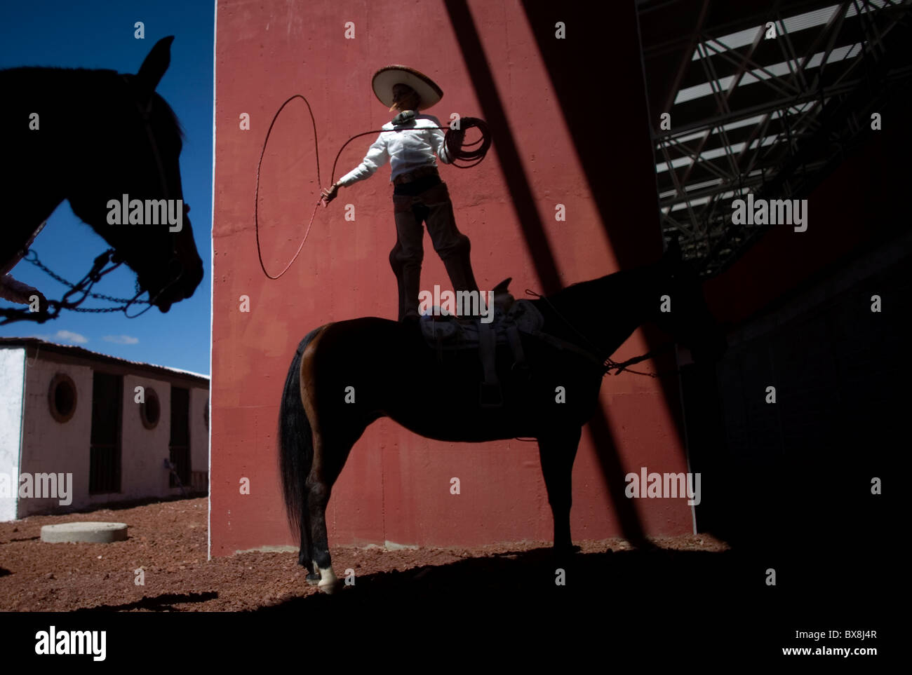 A young Mexican charro practices with his lasso as he stands on his ...