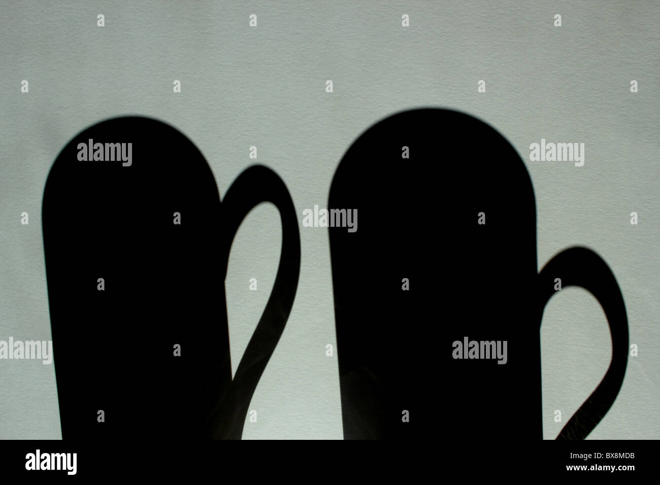 Shadows of two cups in a grey background Stock Photo - Alamy