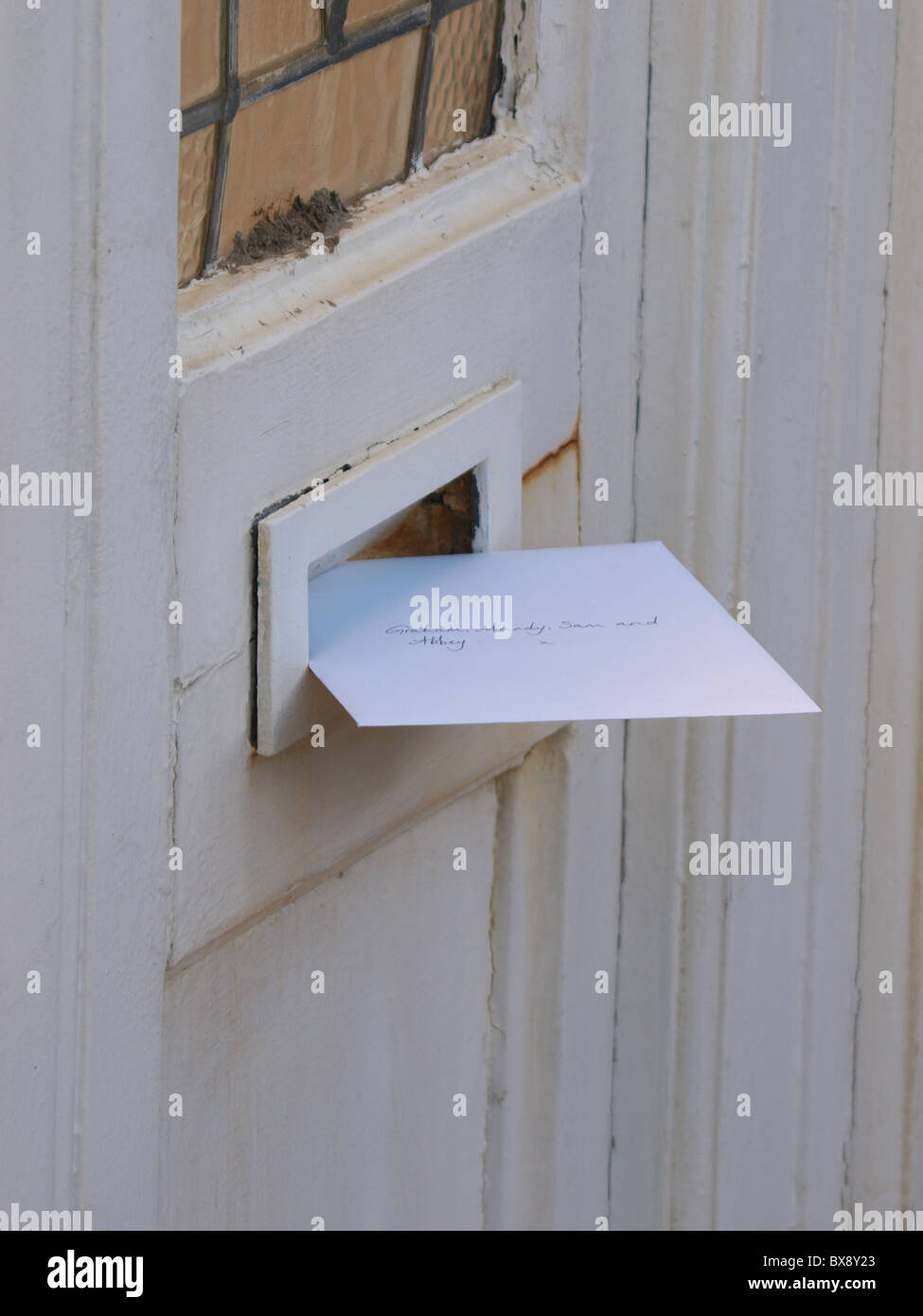 Hand delivered letter hanging out of letterbox, UK Stock Photo - Alamy