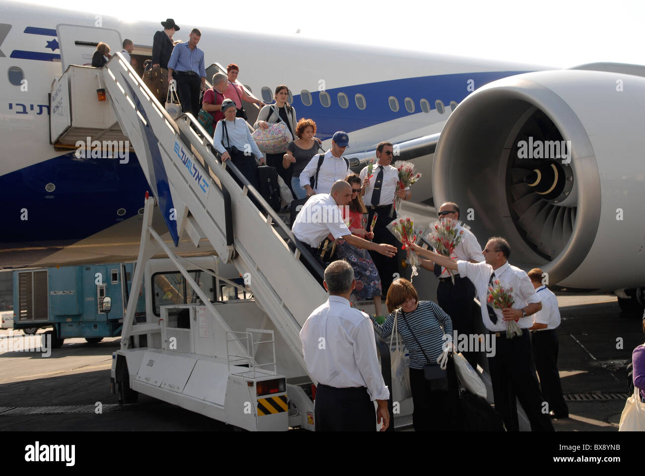 Employees of El Al airline welcome passengers with flowers on arrival ...