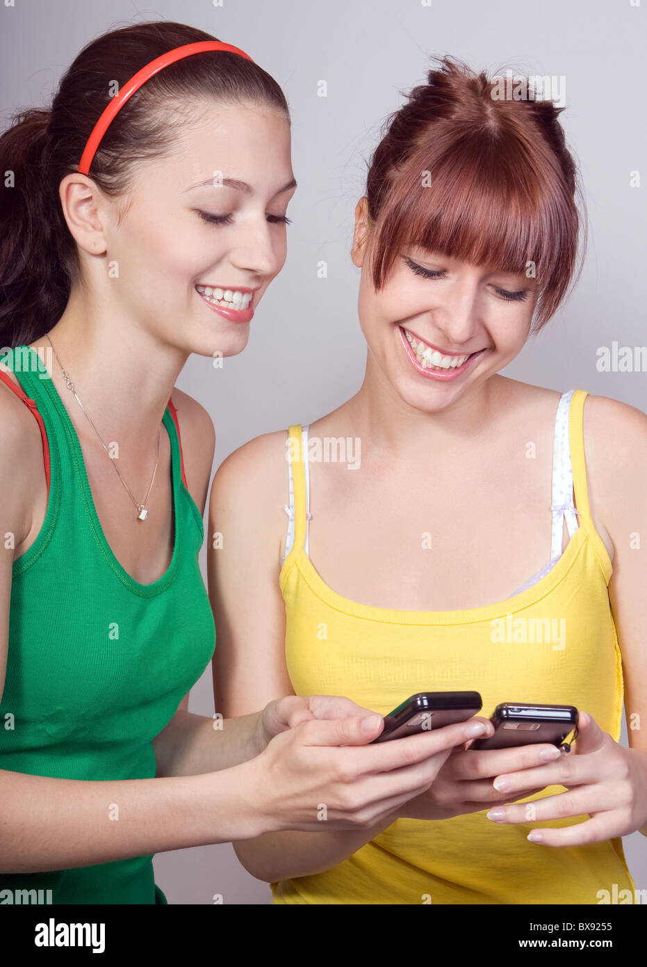 A pair of girls on the phone together Stock Photo - Alamy