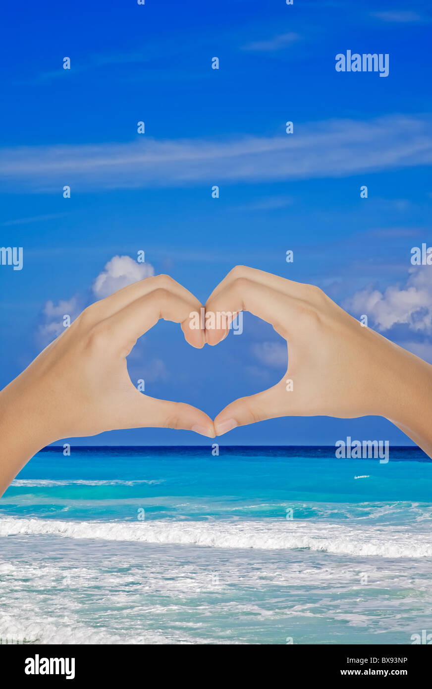 Woman's hands forming a heart with the ocean behide them Stock Photo ...