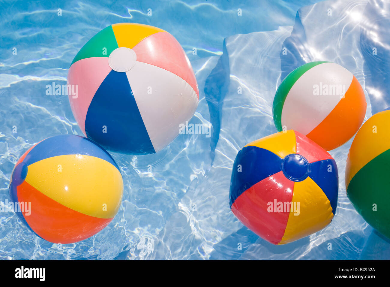 Beachballs in a bright blue pool Stock Photo - Alamy
