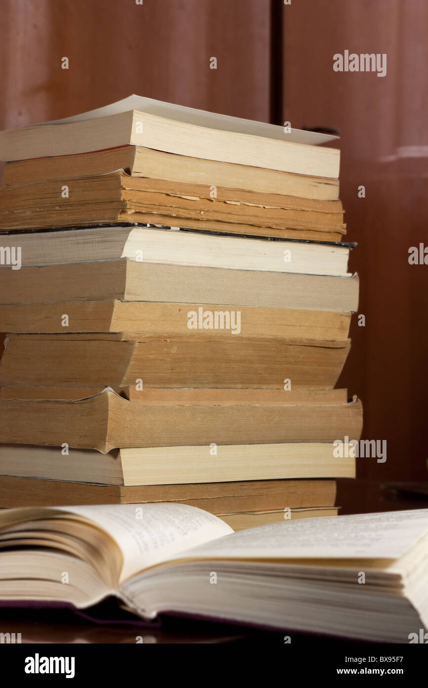 An opened book in front of old,gold edged books Stock Photo - Alamy