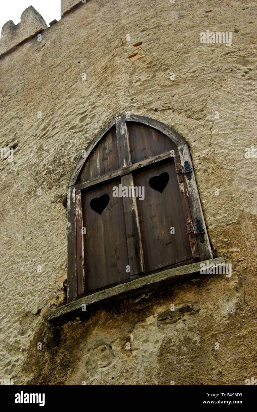 Gothic arch window heart design wooden shutters set in plastered stone ...
