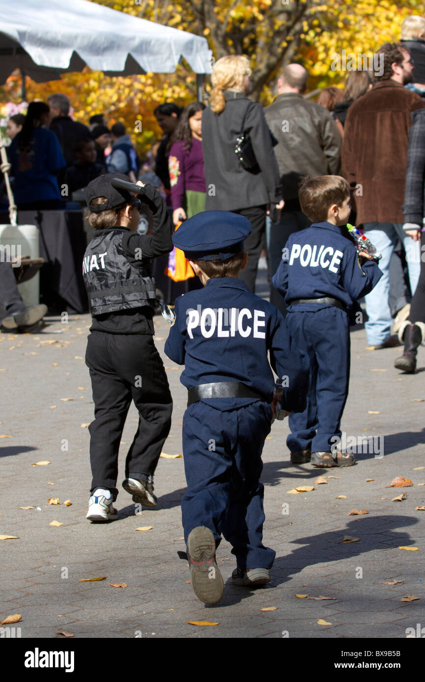 Three young boys dressed as police officers at a Halloween festival in ...