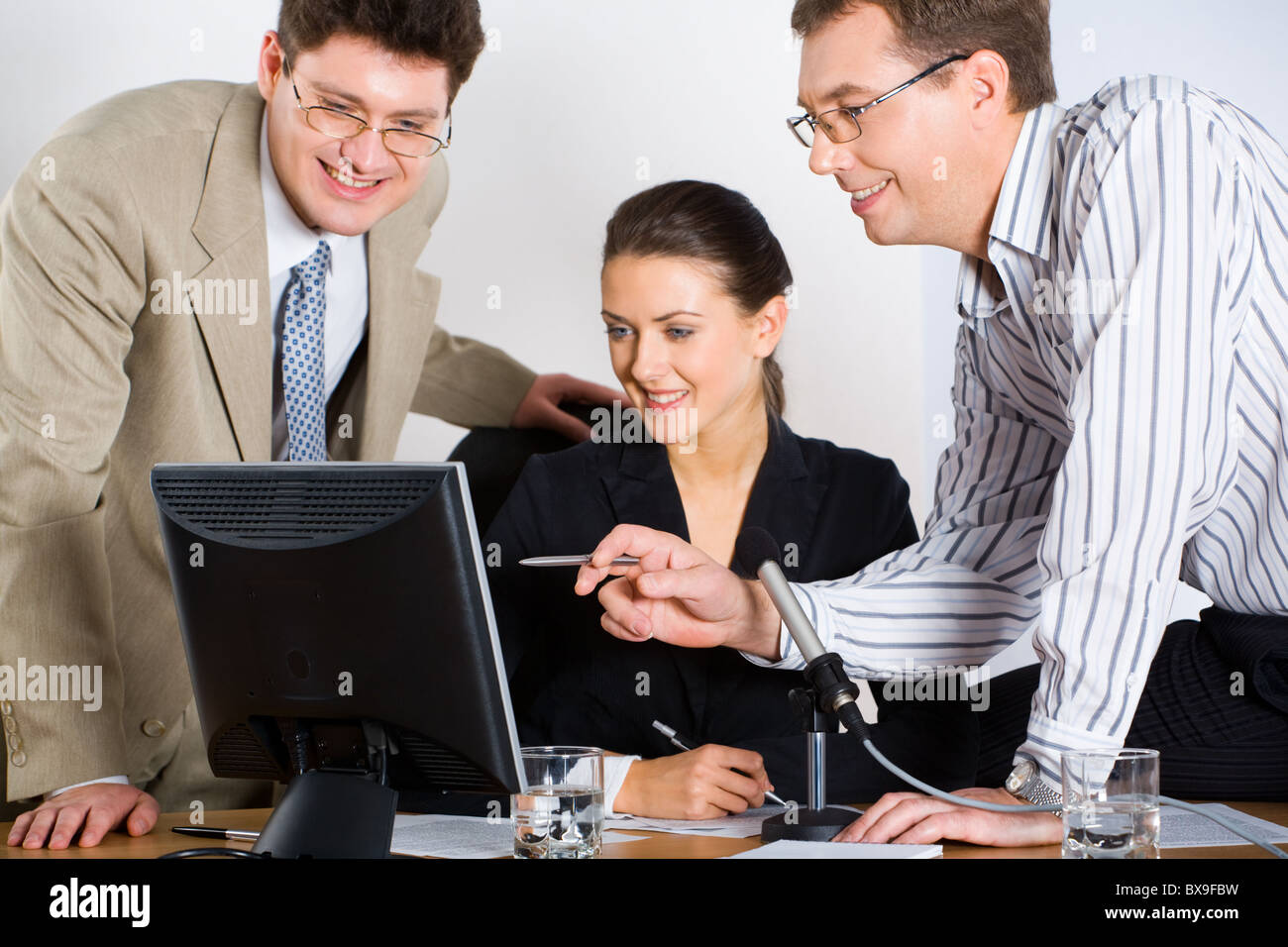 Portrait of three business people looking at monitor of laptop Stock ...