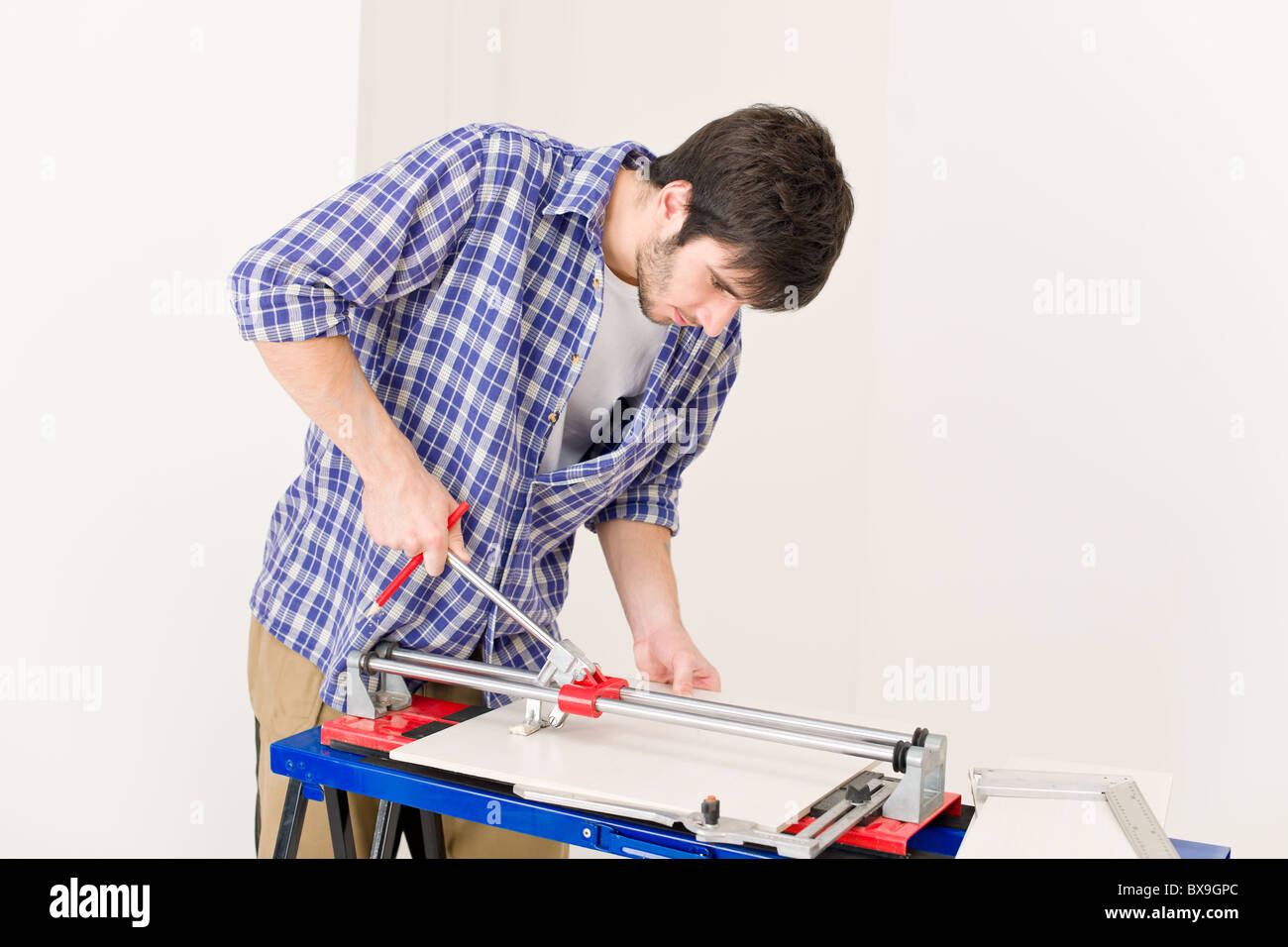Home improvement - handyman cut ceramic tile in workshop Stock Photo ...