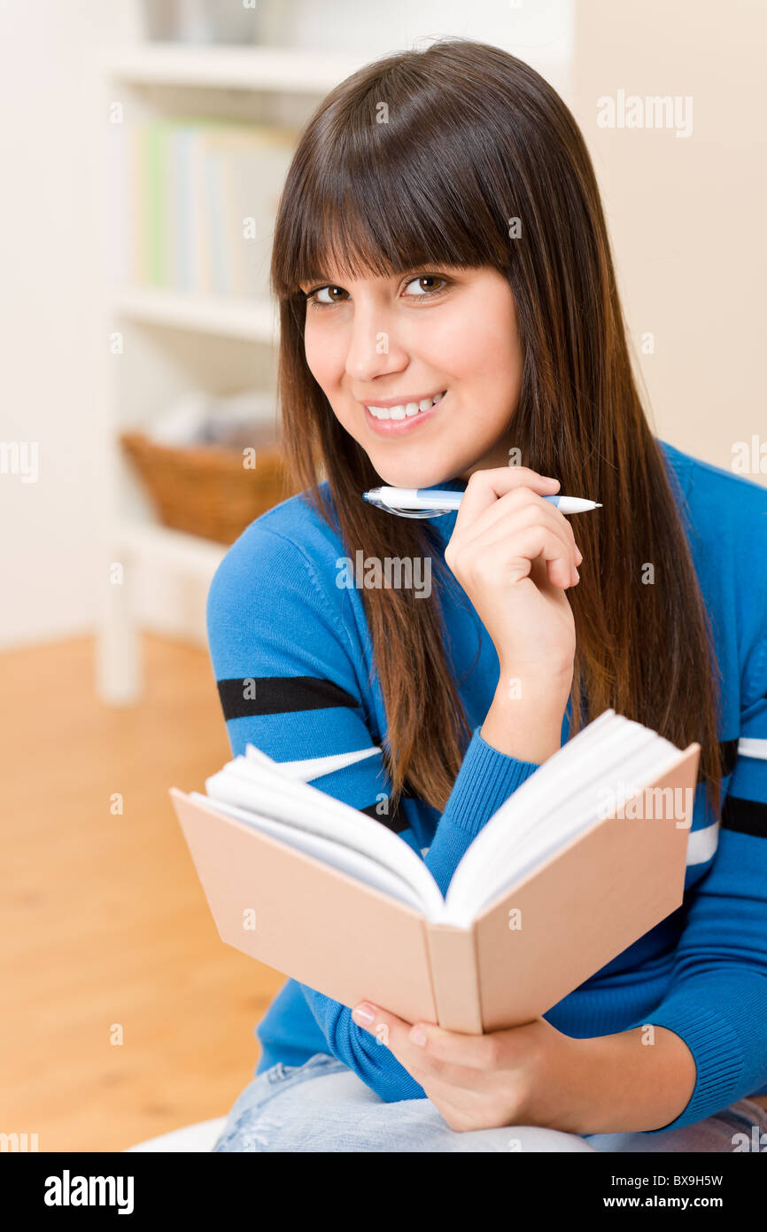 Teenager girl home - happy student with book and pen Stock Photo - Alamy
