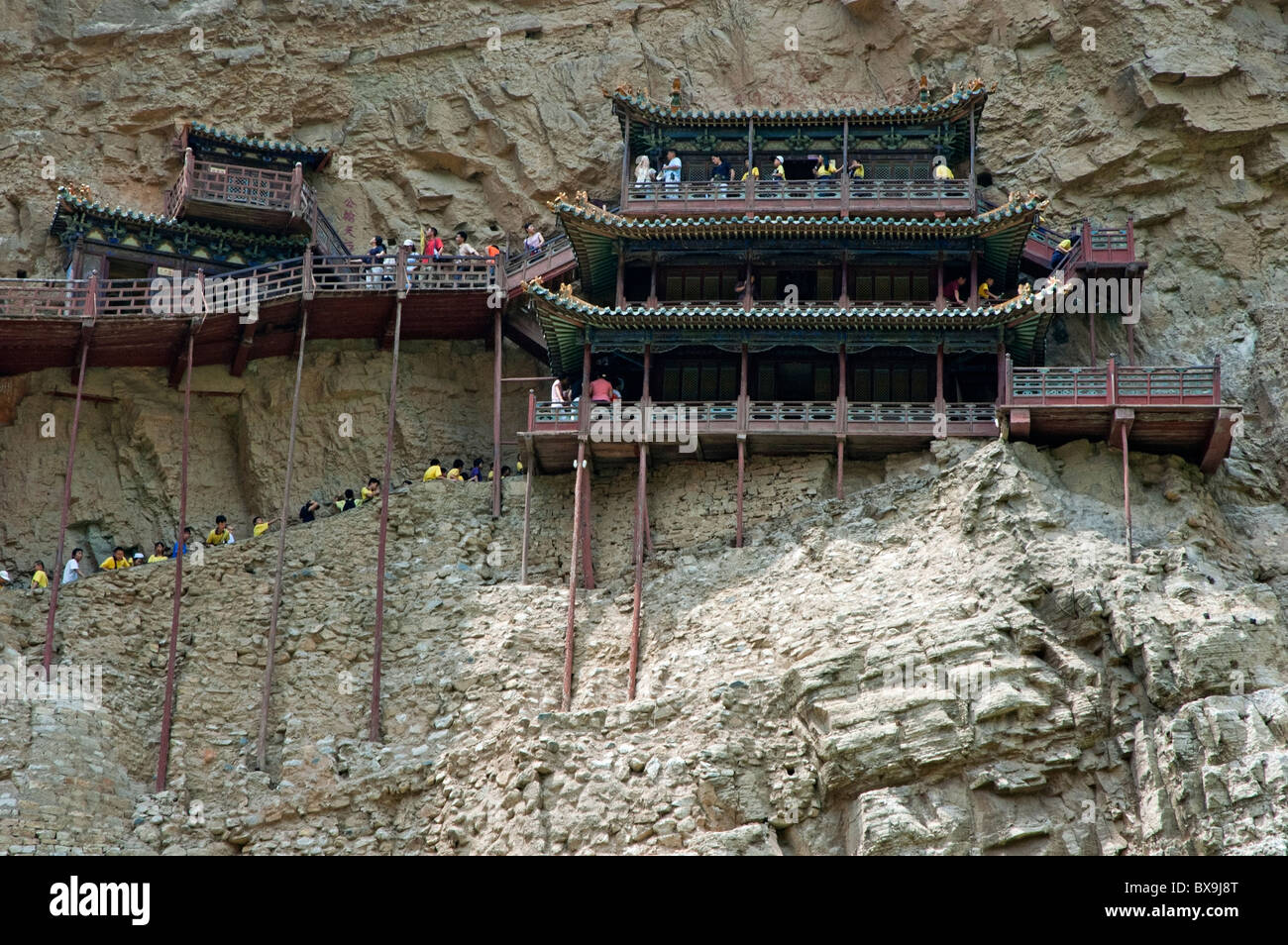 Tourists visiting the Buddhist Hanging Temple Monastery on the side of ...