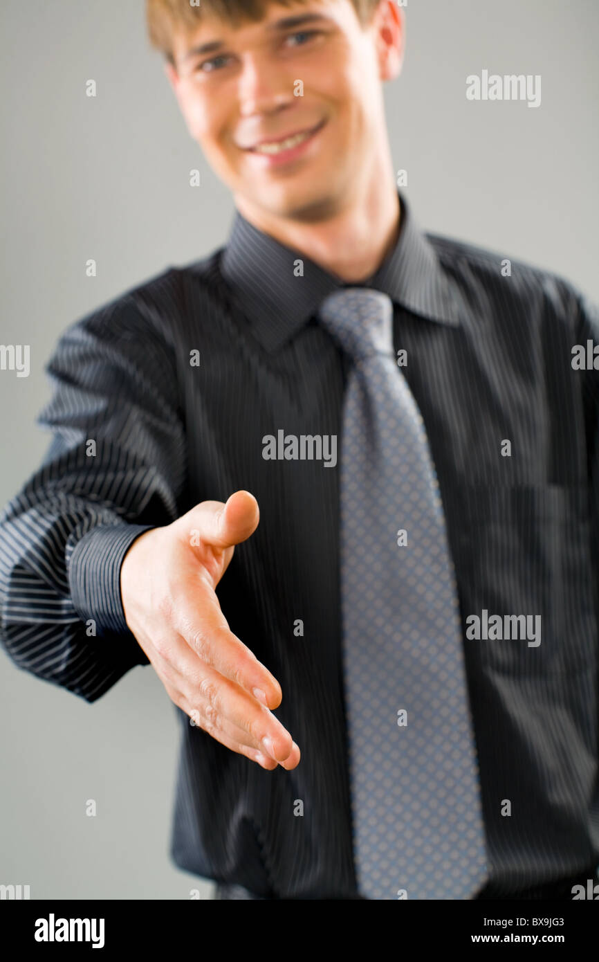 Friendly businessman giving his hand and saying hallo Stock Photo - Alamy