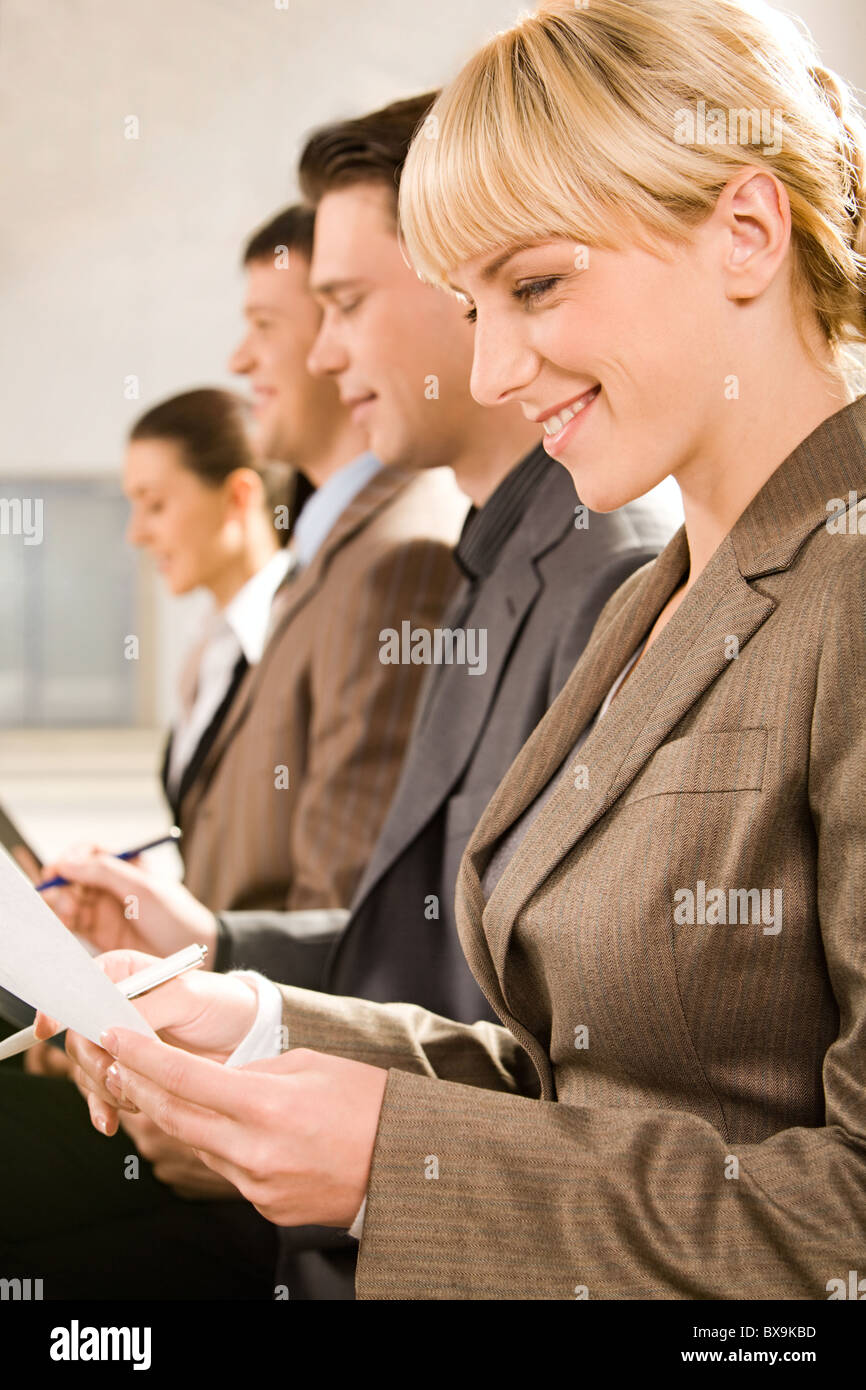 Row of four business people studing a document at seminar Stock Photo ...