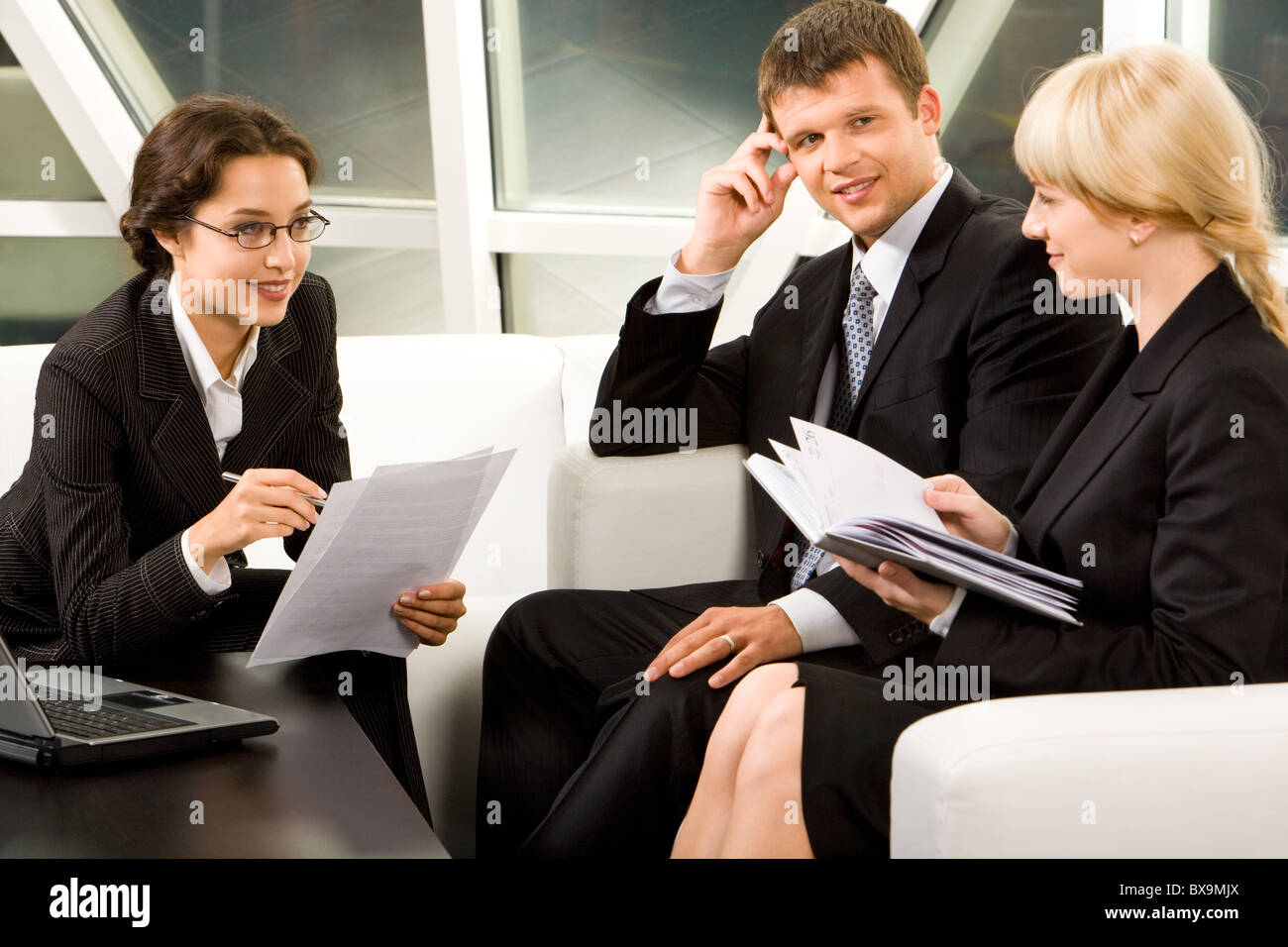 Portrait of three white collar workers discussing a new idea Stock ...