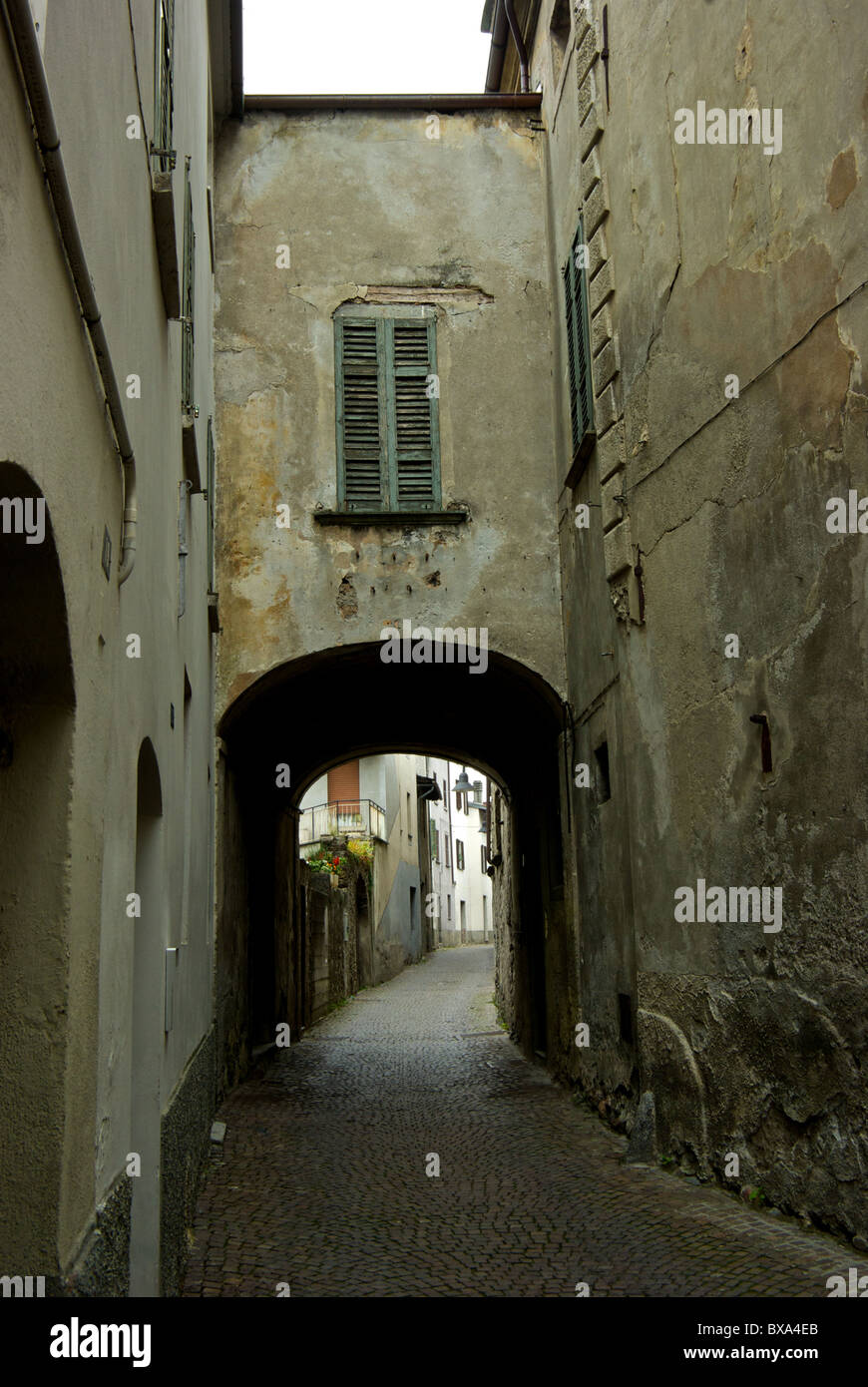 Narrow pedestrian passageway between stucco clad residential apartment ...