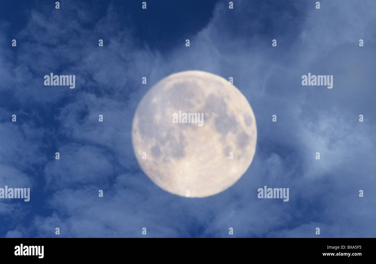 Full moon behind light clouds Stock Photo - Alamy