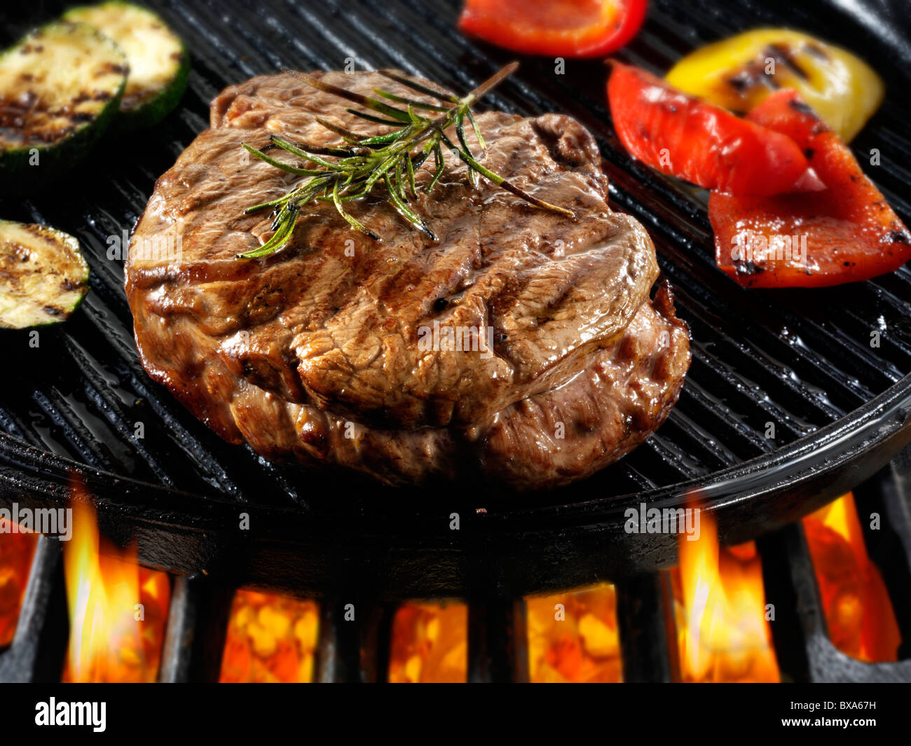 Beef fillet steaks & roast peppers being pan fried on a bbq. Meat food ...