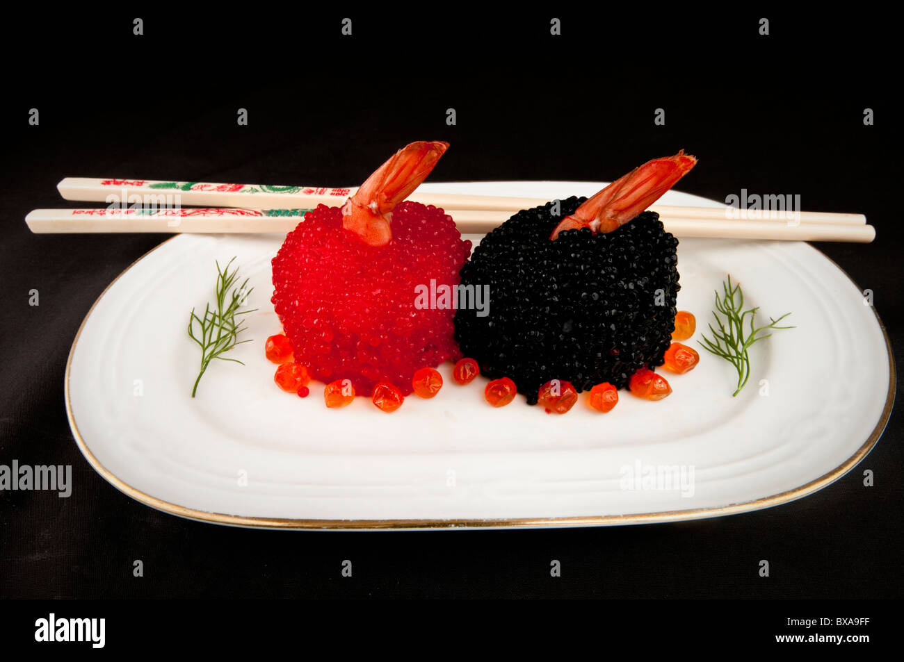 Sushi covered with red and black fish eggs garnished with dill and ...