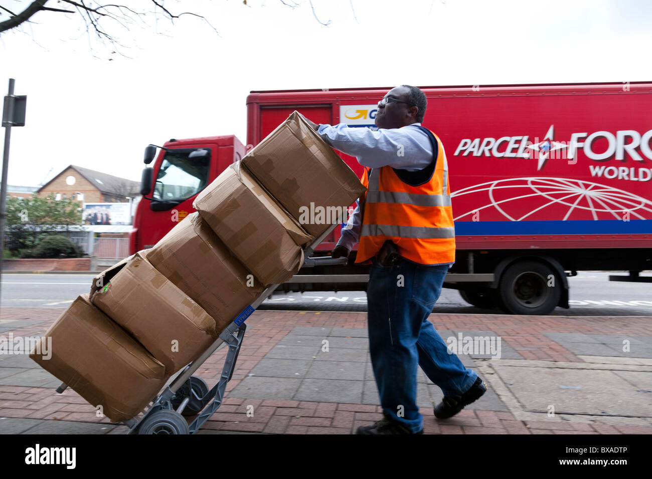 Delivery man pushing trolley parcels hi-res stock photography and ...