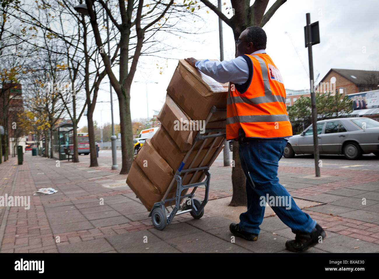 Delivery man pushing trolley parcels hi-res stock photography and ...