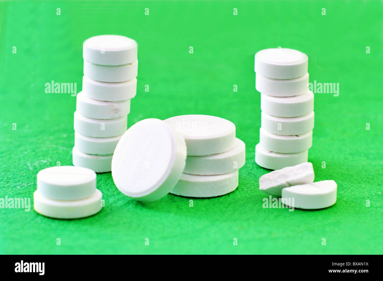 White tablets a hill on a table with a green cloth Stock Photo - Alamy
