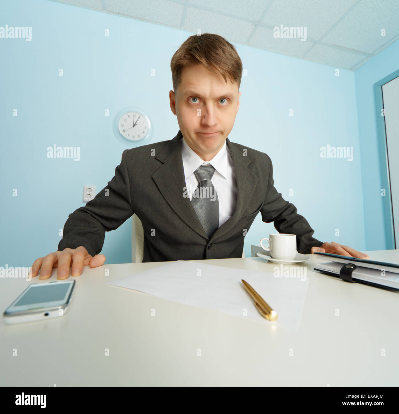 Angry boss looks at the slave sitting at the table Stock Photo - Alamy