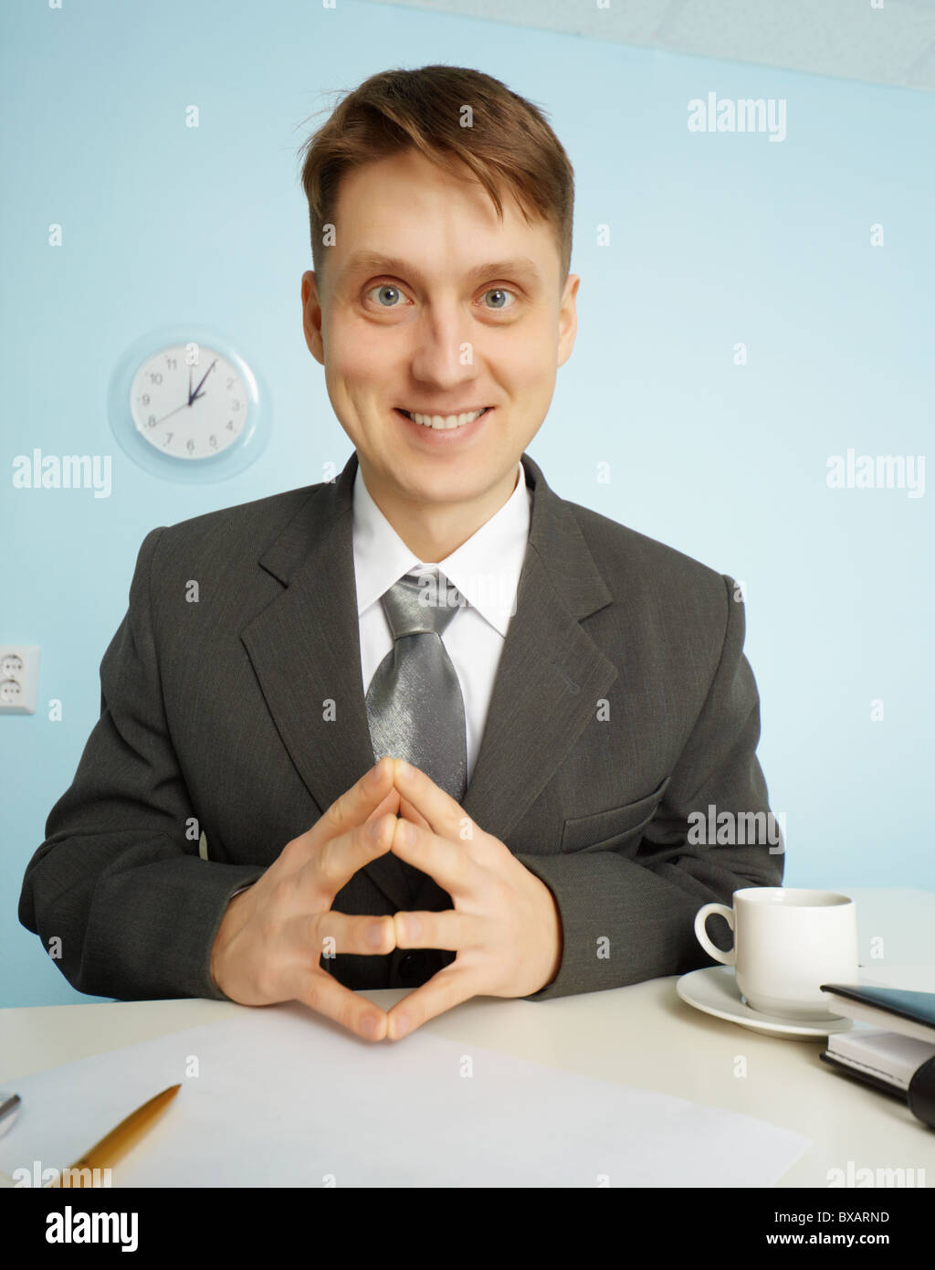 Happy clerk sitting at his desk with a smile Stock Photo - Alamy