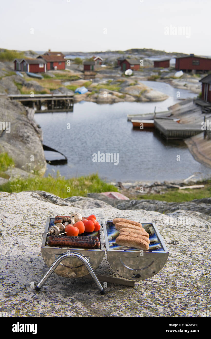 Barbecue grill with meal on rock Stock Photo - Alamy