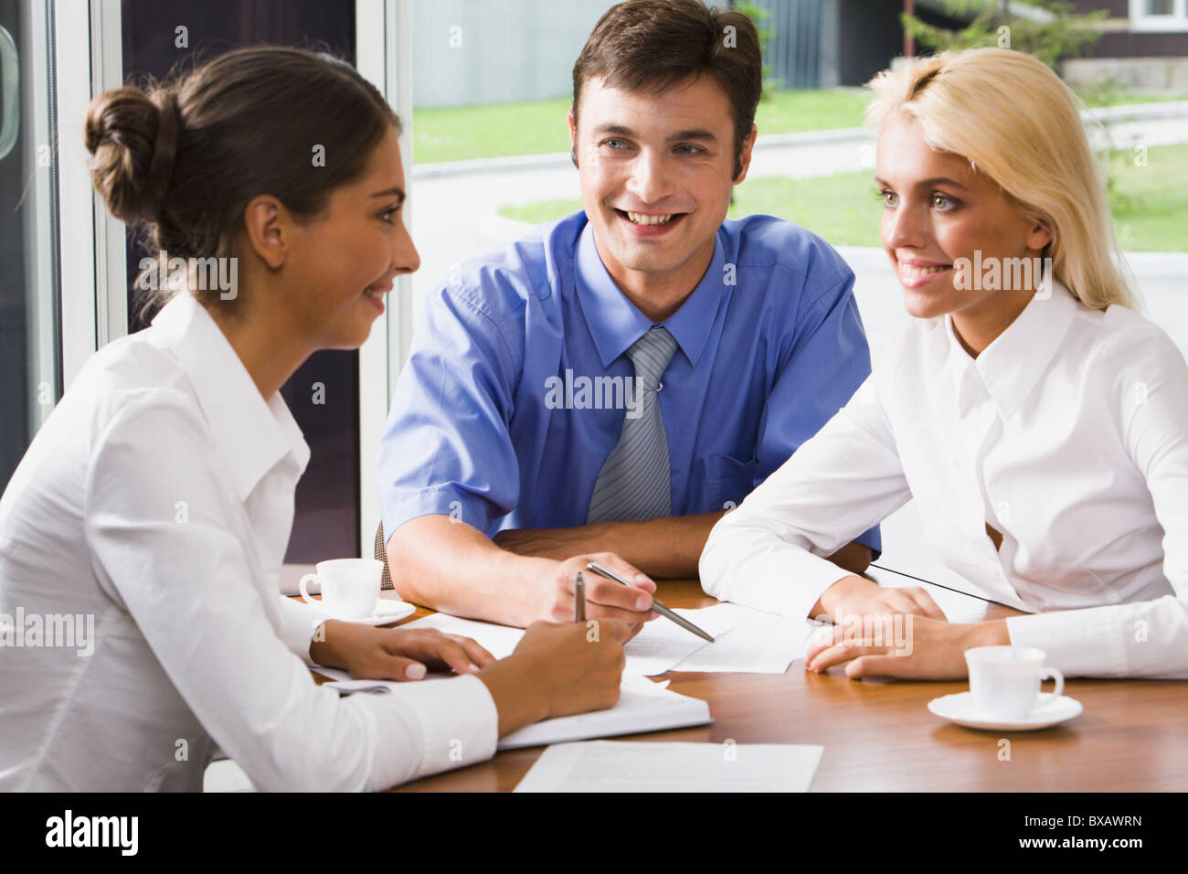 Three business persons are discussing ideas in the office Stock Photo ...