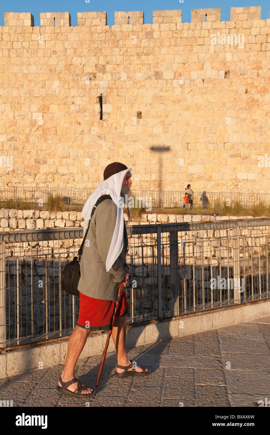 man in oriental exotic clothes at Jaffa gate with city walls in bkgd ...