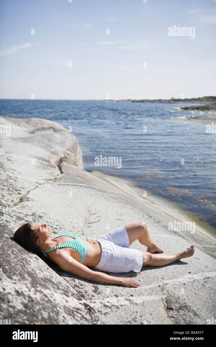 Woman lying on rock Stock Photo - Alamy