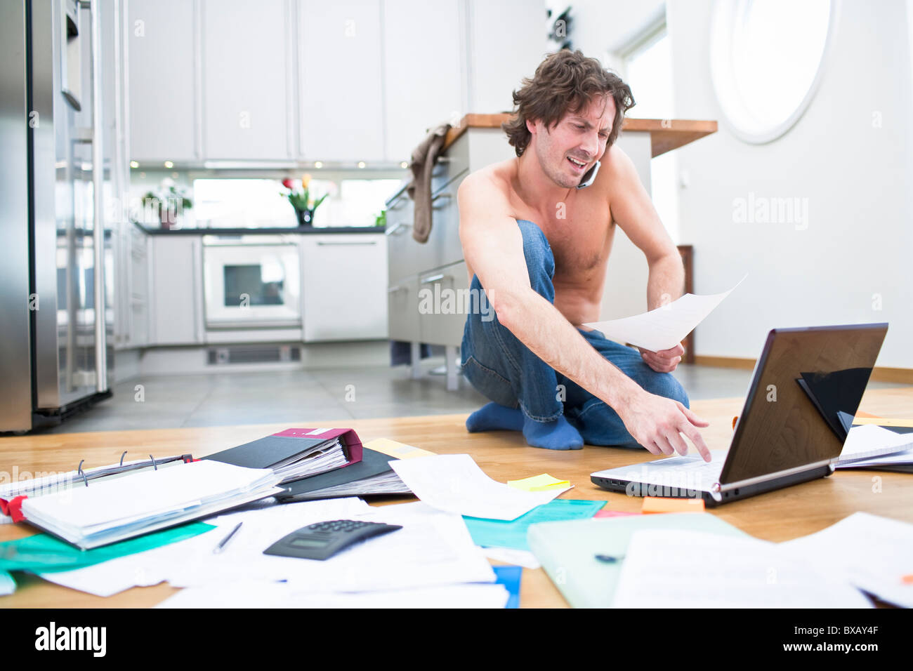 Frustrated man struggling with domestic paperwork Stock Photo - Alamy