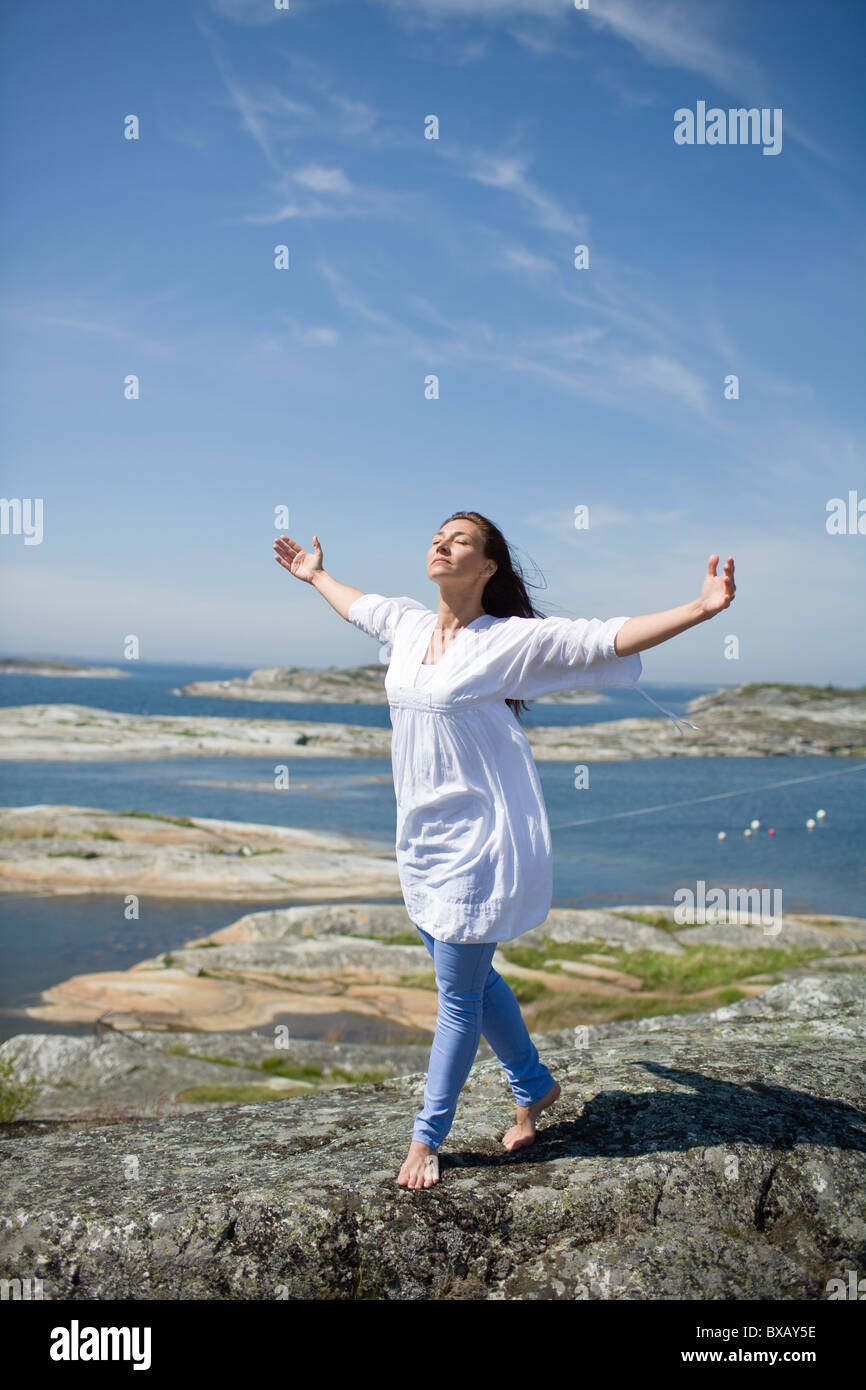 Woman walking on rock with arms up Stock Photo - Alamy