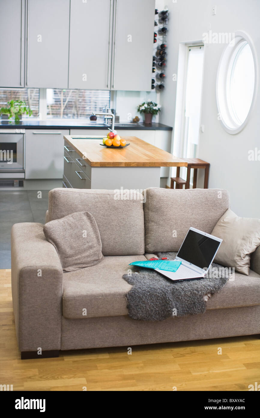 Laptop on sofa in living room Stock Photo - Alamy