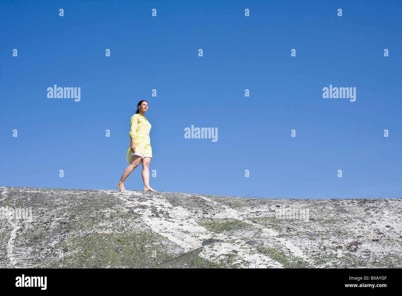 Woman walking on rock Stock Photo - Alamy