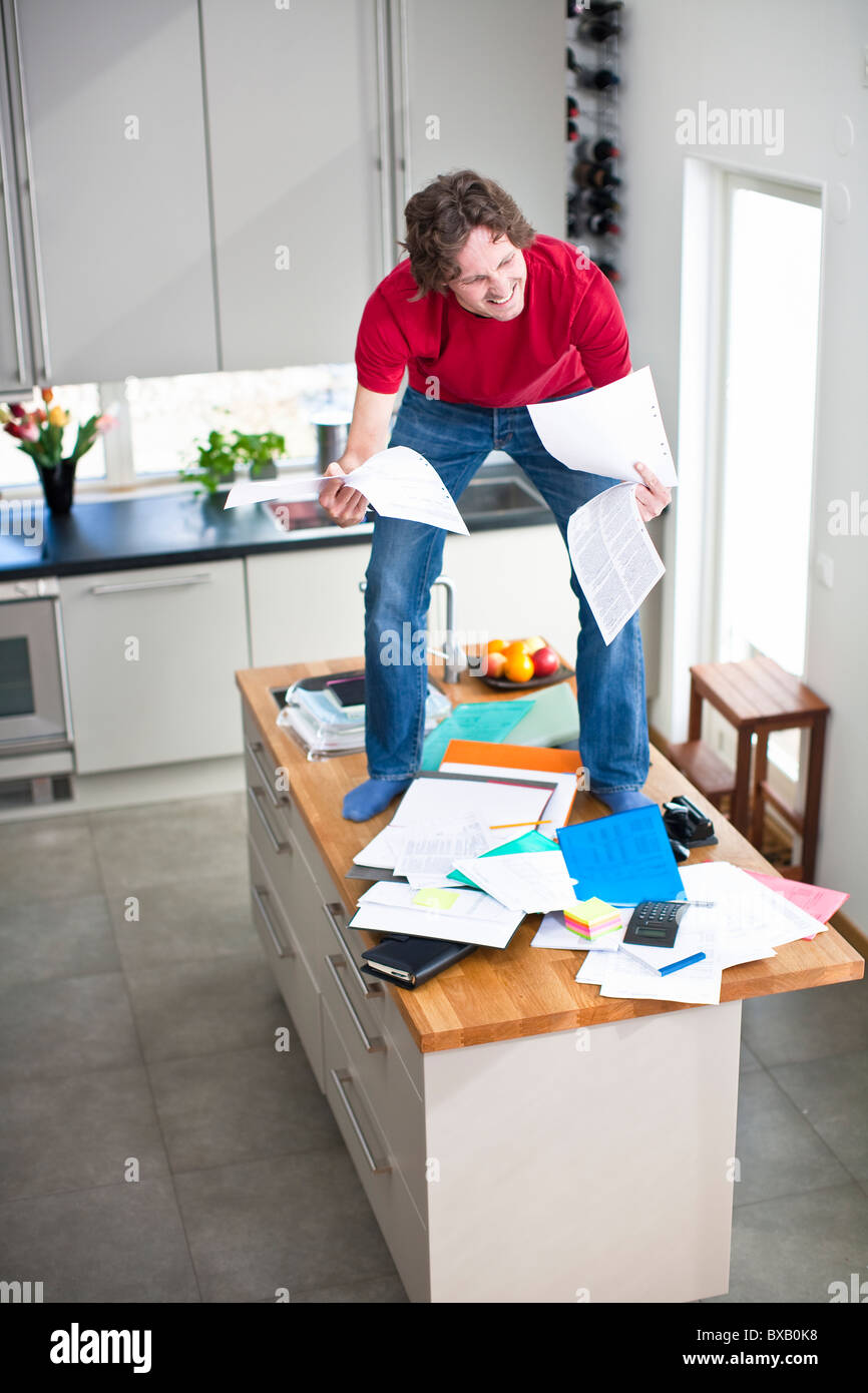 Man struggling with domestic paperwork Stock Photo - Alamy