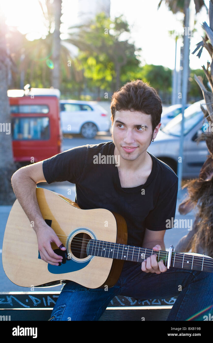 Portrait of young man playing guitar, outdoors Stock Photo - Alamy