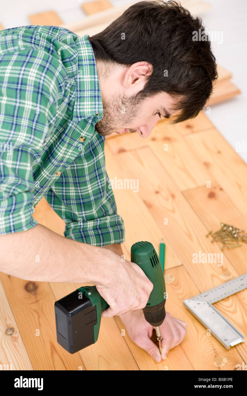Home improvement - handyman installing wooden floor Stock Photo - Alamy