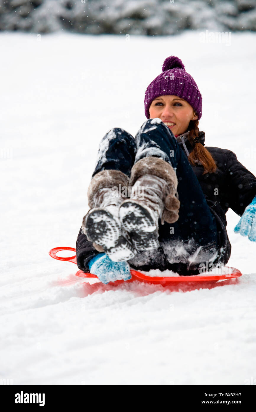 Sledding young woman Stock Photo - Alamy